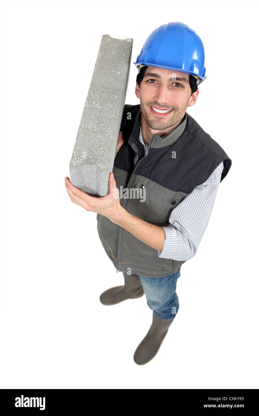 Man carrying breeze block Stock Photo - Alamy