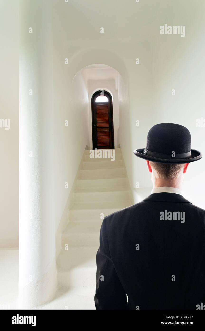 man facing door at end of stairwell Stock Photo - Alamy