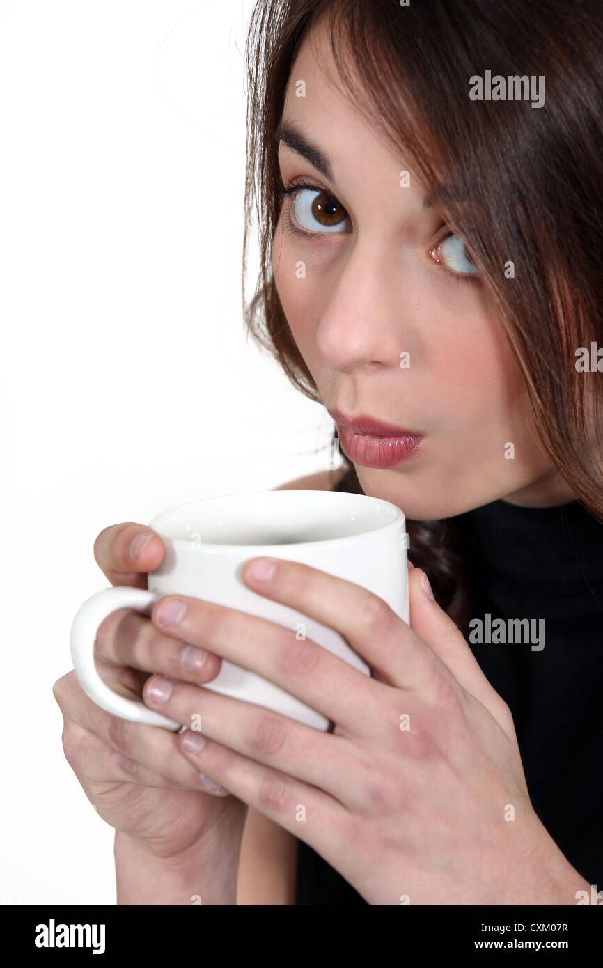 A woman blowing on her drink Stock Photo - Alamy