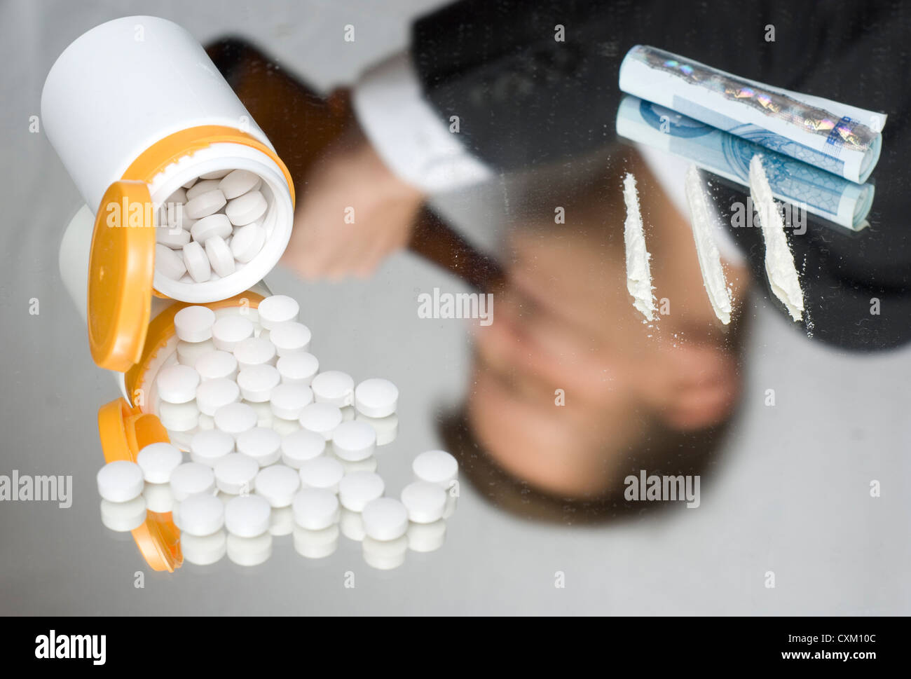 Drugs on a mirror. Out of focus reflection of a drinking businessman ...