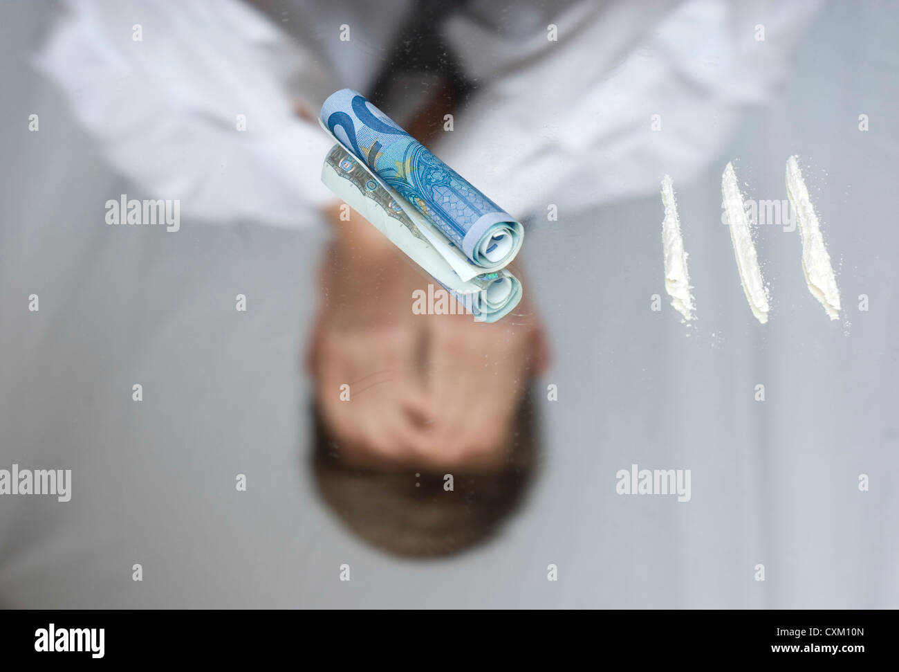Cocaine and money on a mirror. Out of focus reflection of a businessman ...