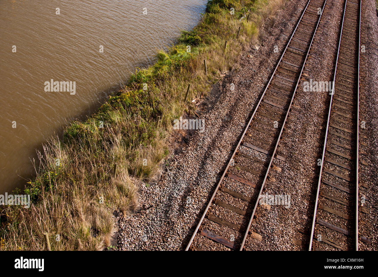 Railway line alongside water Stock Photo - Alamy