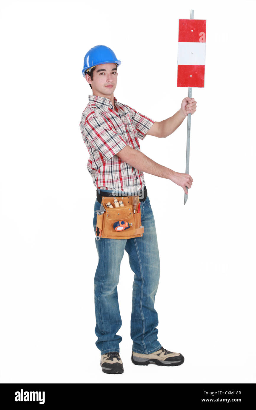 Worker holding up road sign Stock Photo - Alamy