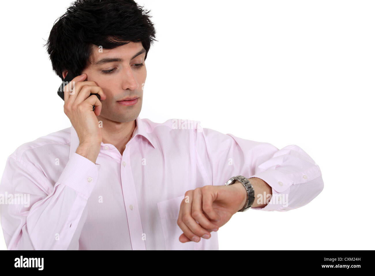 man talking on his cell and watching his watch Stock Photo - Alamy