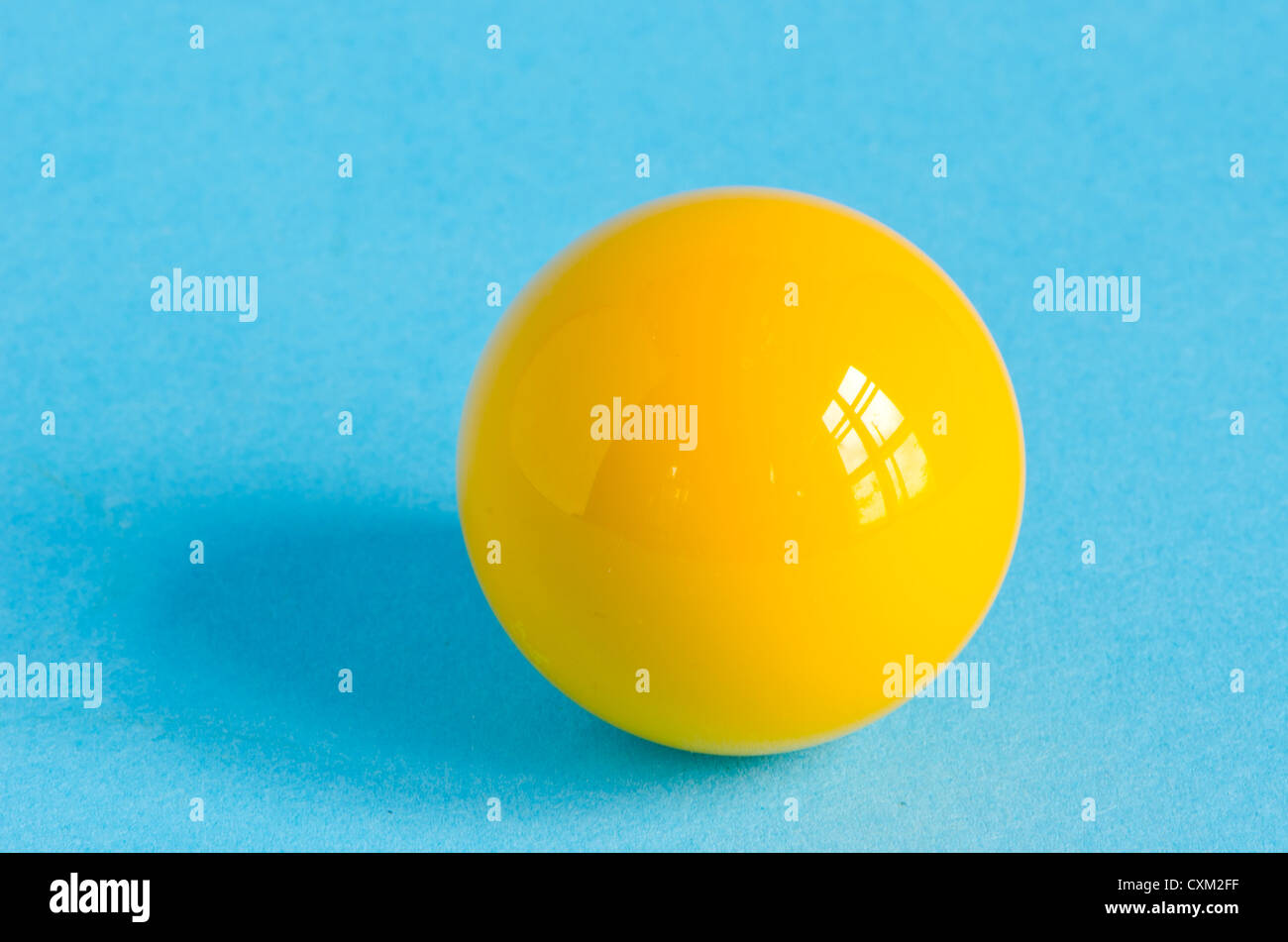 one yellow billiards ball on azure background with windows reflection ...