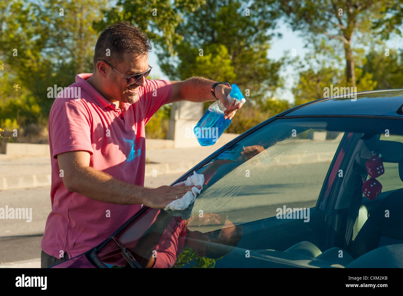 Male cleaning his car windscreen outdoors Stock Photo - Alamy
