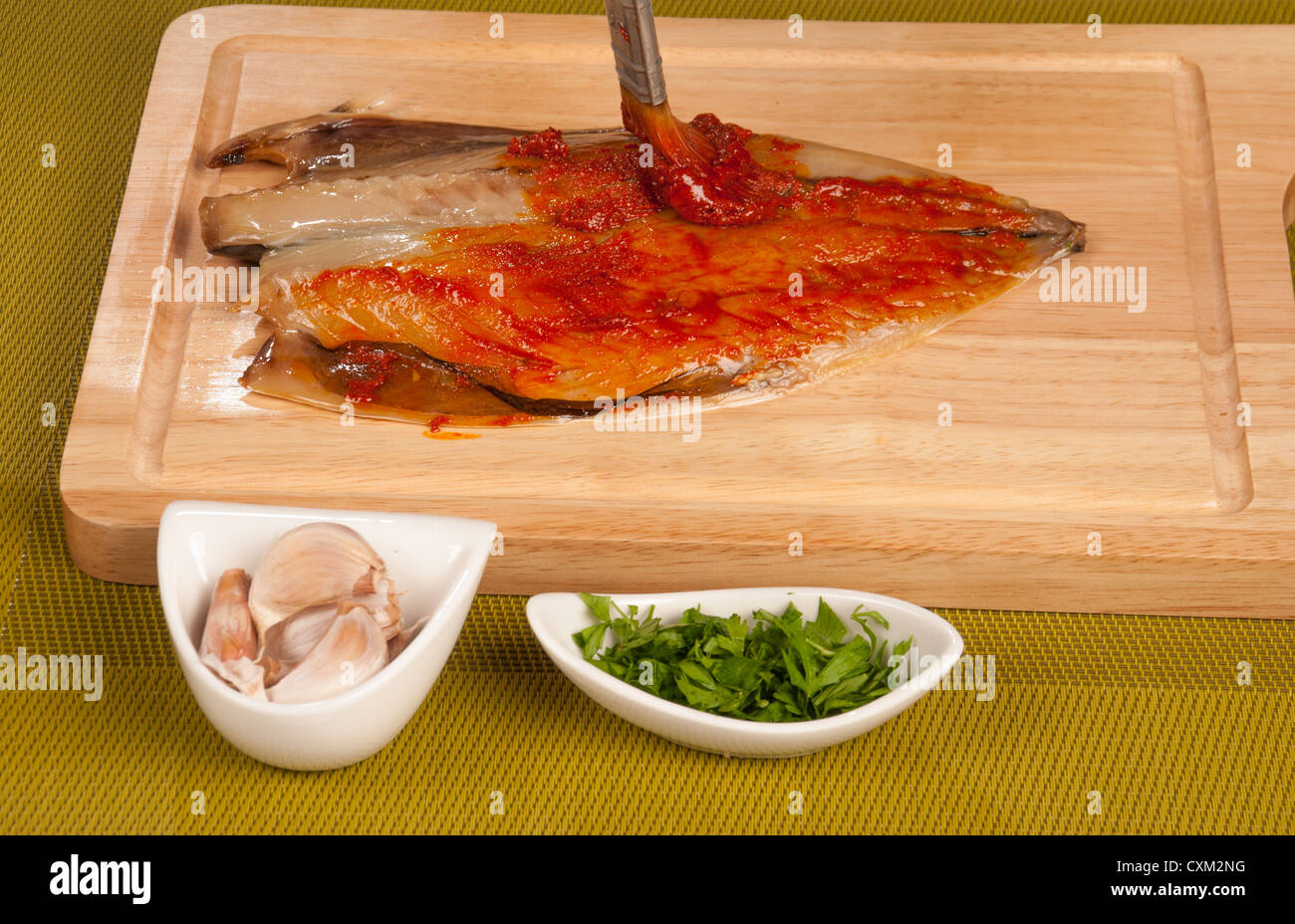 Salt preserved mackerel being brushed with a spicy marinade Stock Photo ...