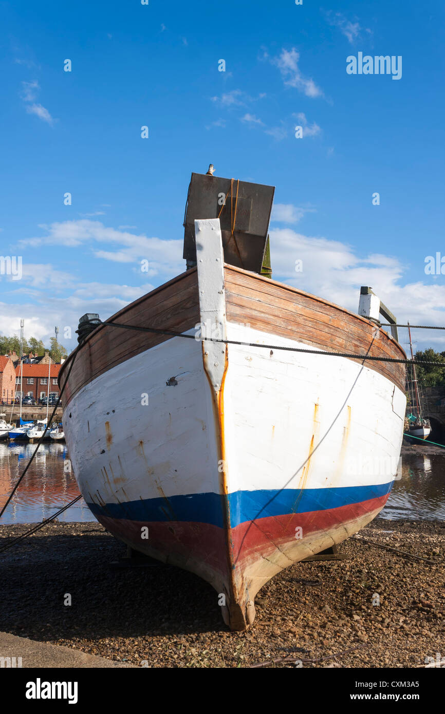 An old wooden clinker built fishing boat / trawler on the bank of the ...
