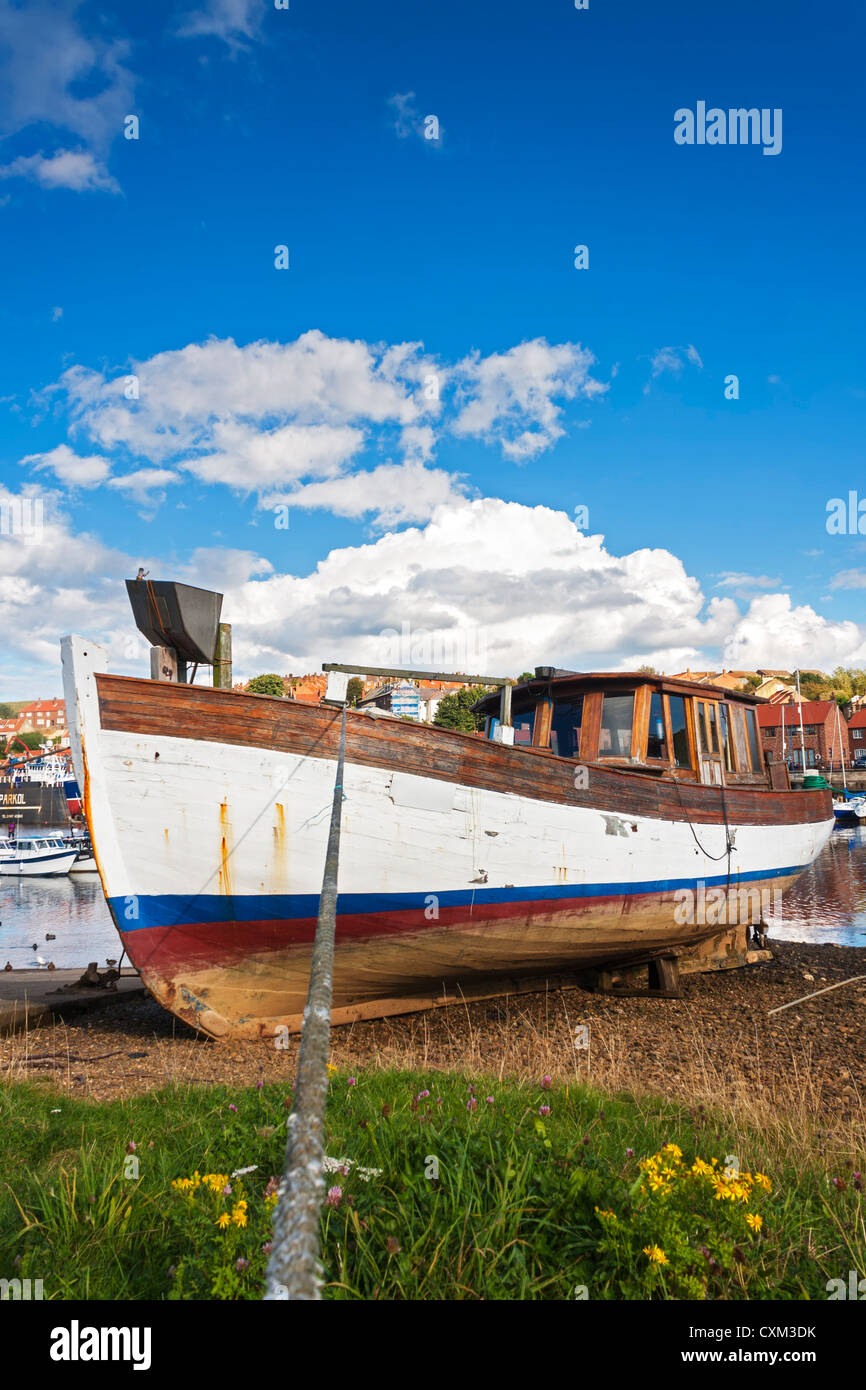 An old wooden clinker built fishing boat / trawler on the bank of the ...