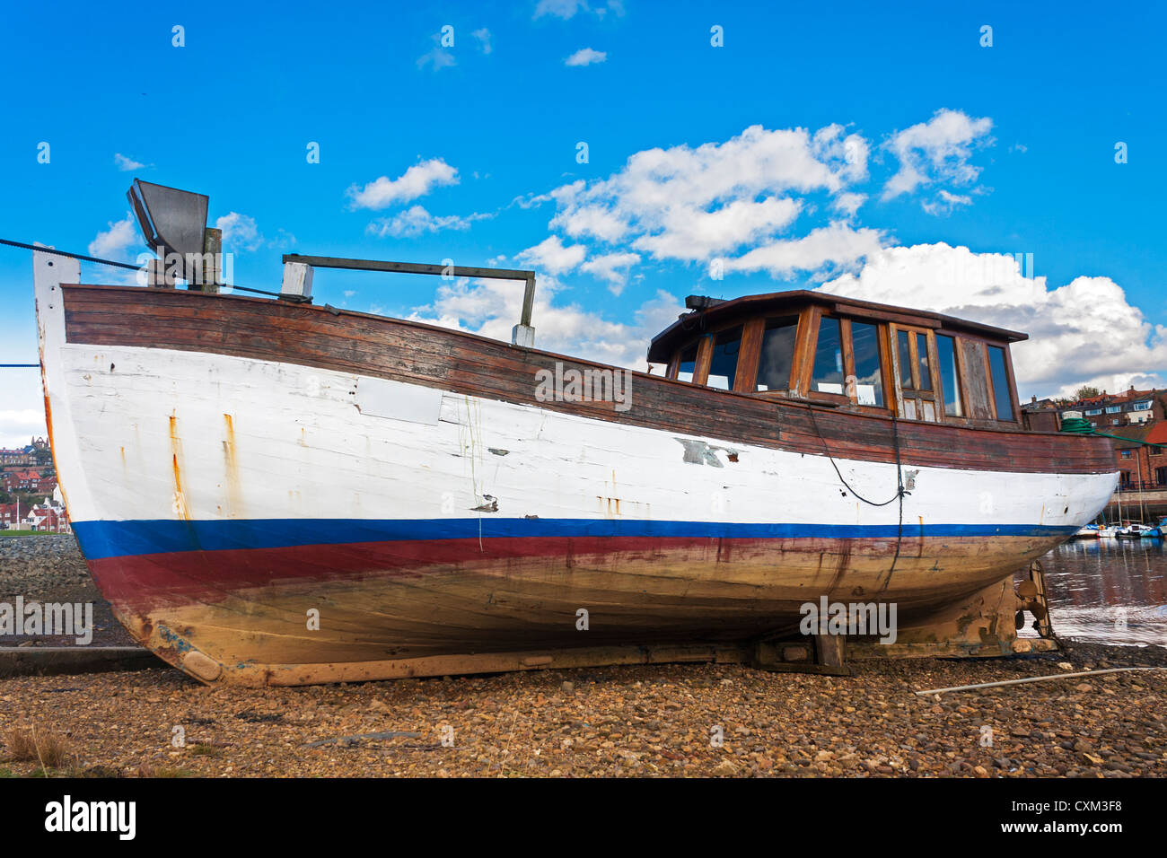 An old wooden clinker built fishing boat / trawler on the bank of the ...