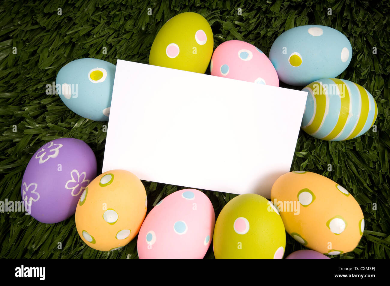 A white note card surrounded by brightly colored Easter eggs, insert ...