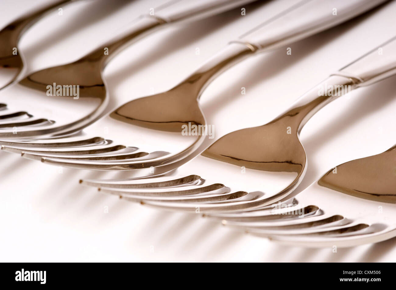 A row of white dinner forks on a white background Stock Photo - Alamy