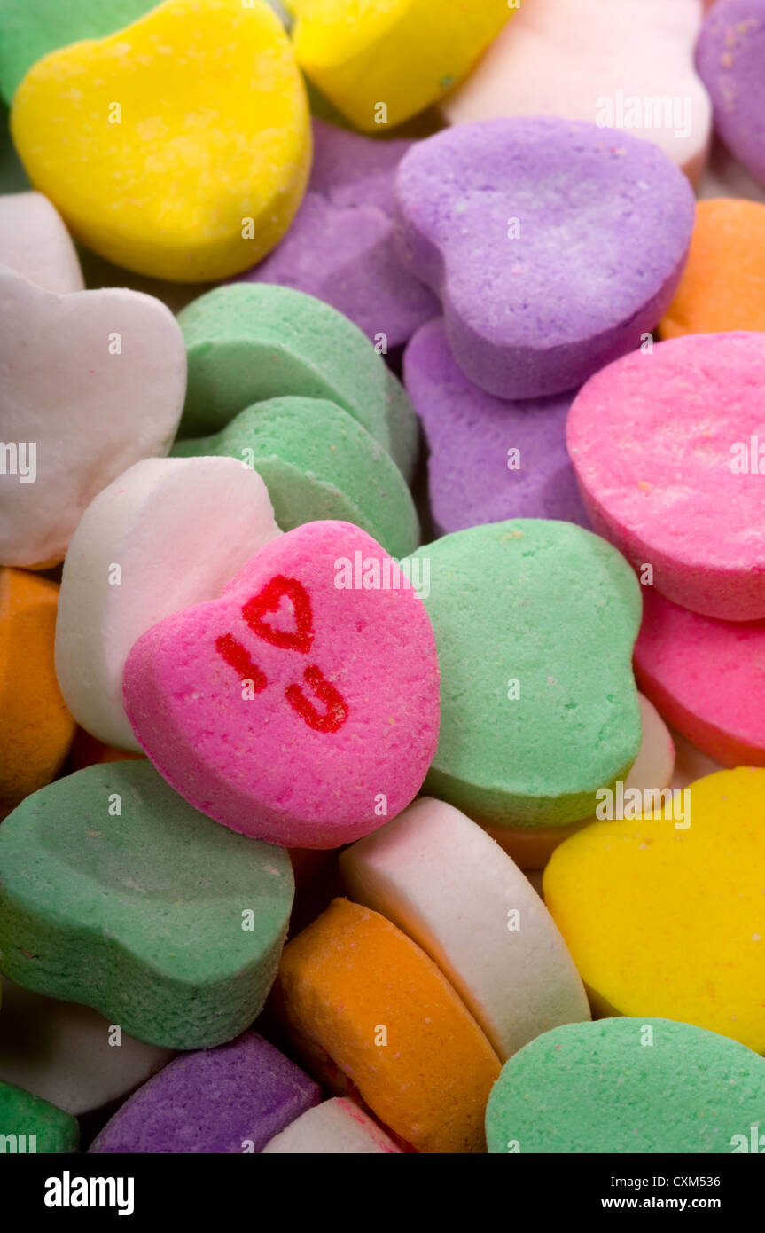 A stack of candy conversation hearts with one turned up with the words ...