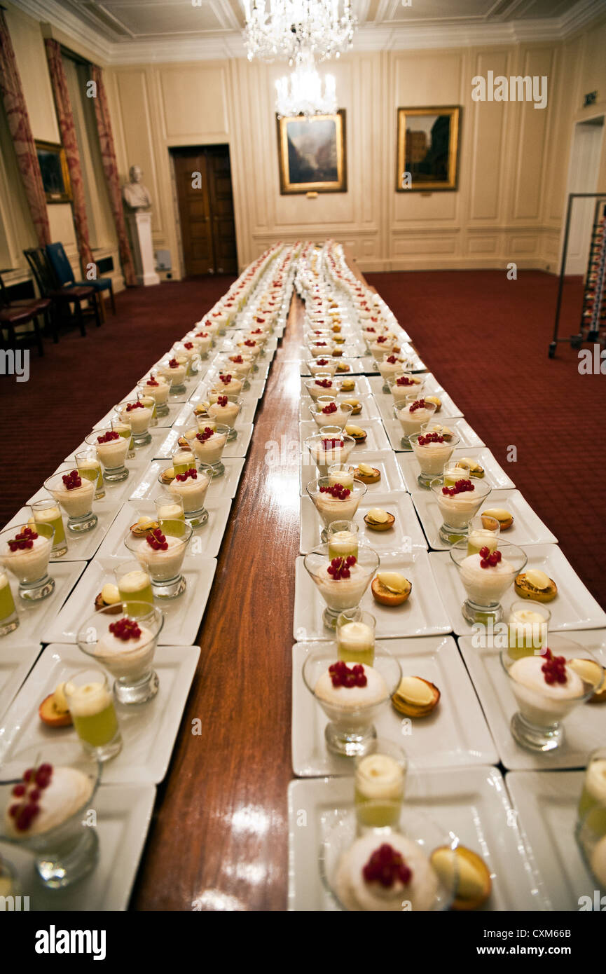 Table covered with rows of identical blancmange-type puddings, prepared ...