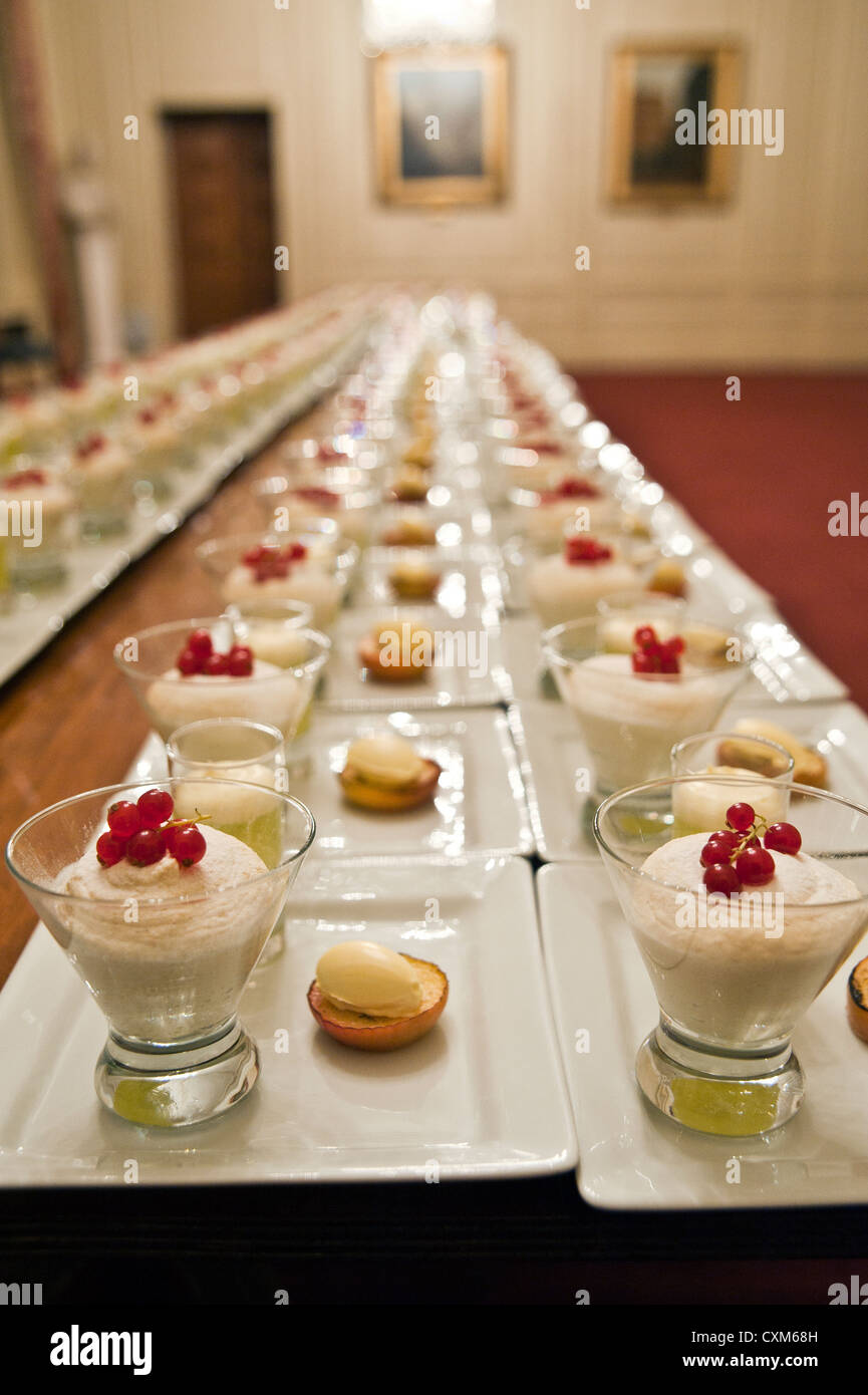 Table covered with rows of identical blancmange-type puddings, prepared ...