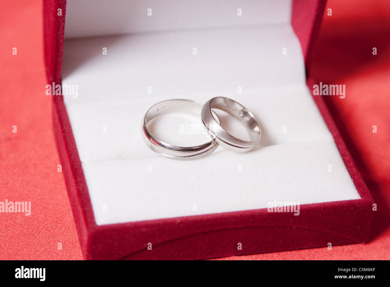 Wedding rings in red box, over red background Stock Photo - Alamy