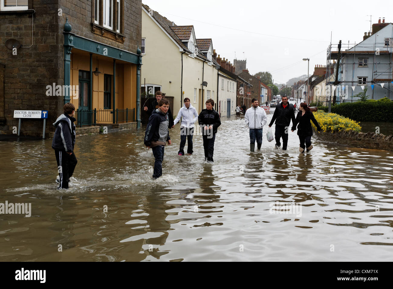 Young people wading through a flooded South Street in Bridport, Dorset ...