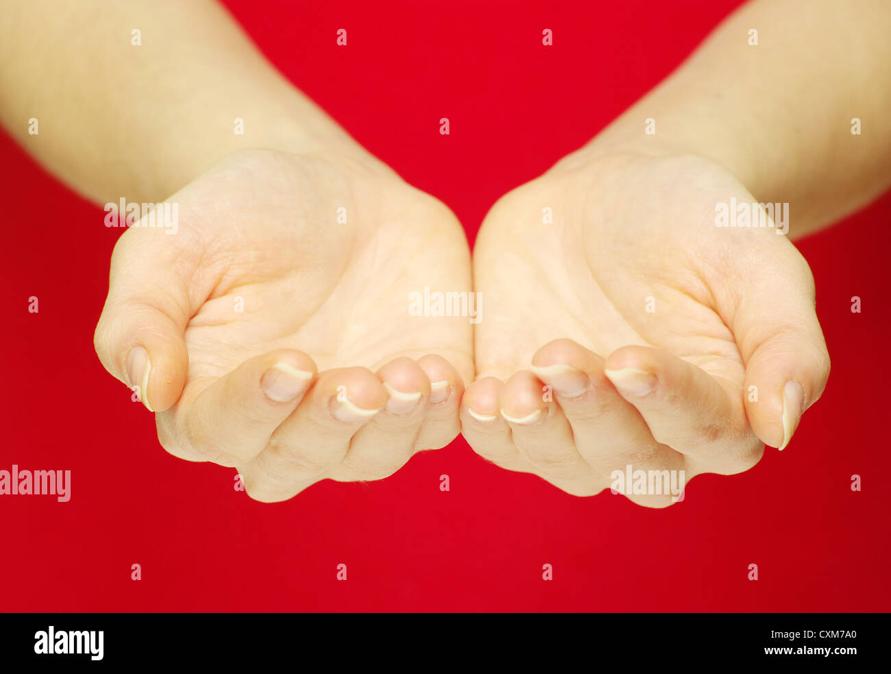A hand begging alms on a red background Stock Photo - Alamy