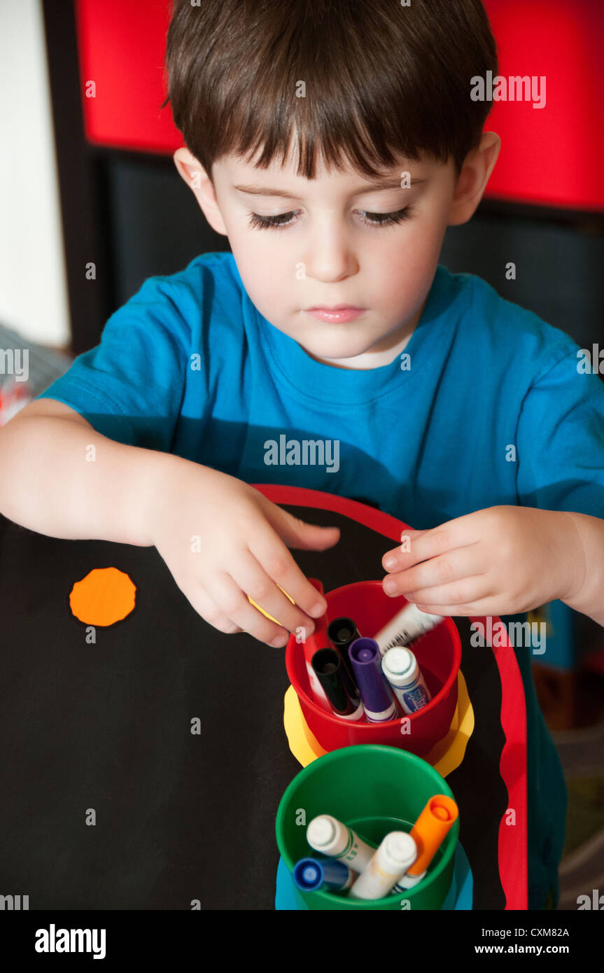 Child choosing crayons to draw -model released Stock Photo - Alamy