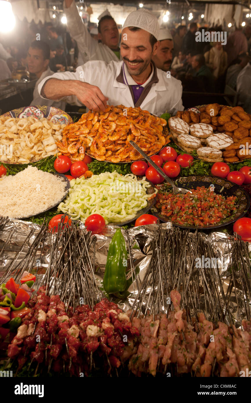 food display in market stall with local cook arranging prawns in Jamaa ...