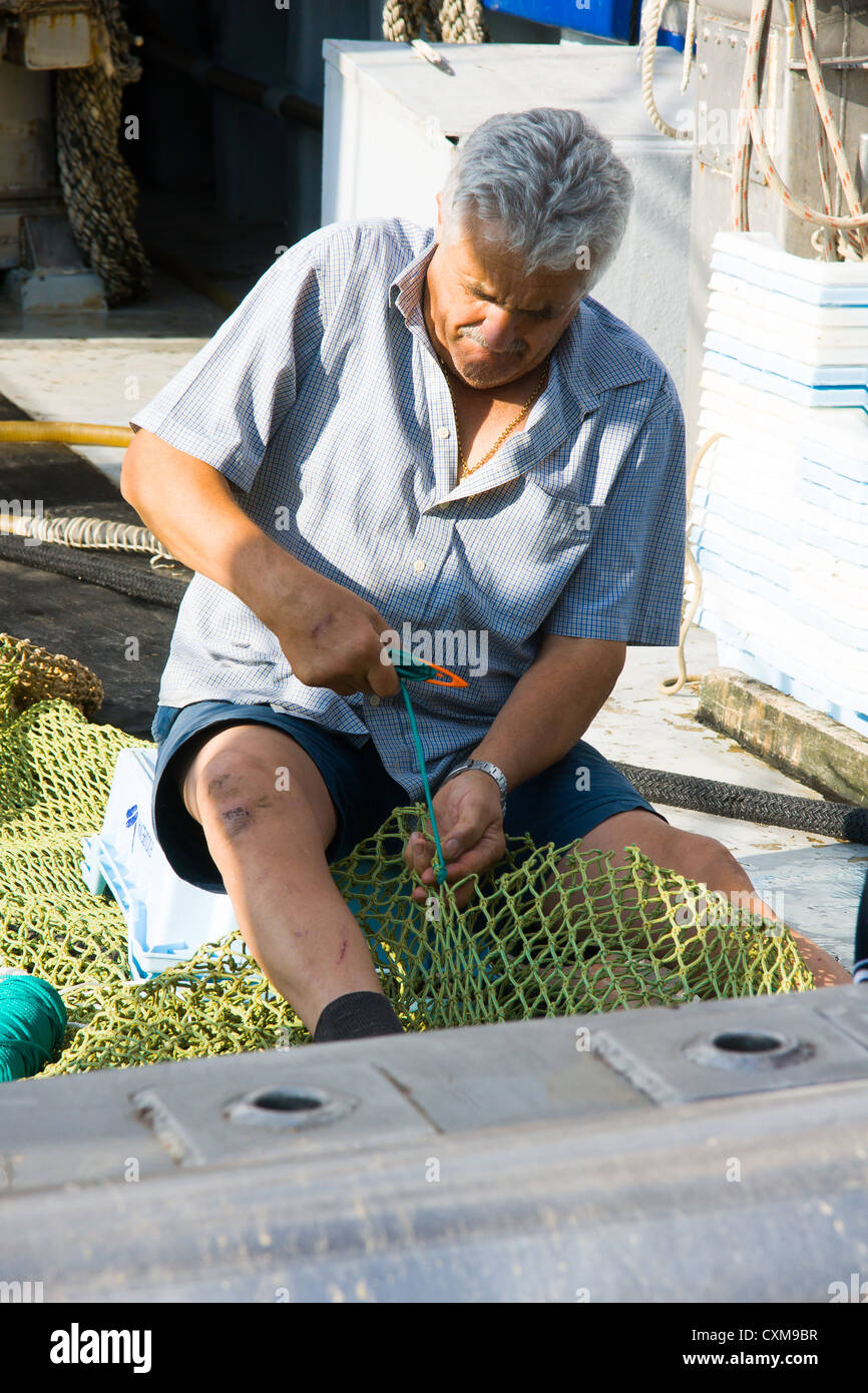 A fisherman mending his nets Stock Photo - Alamy