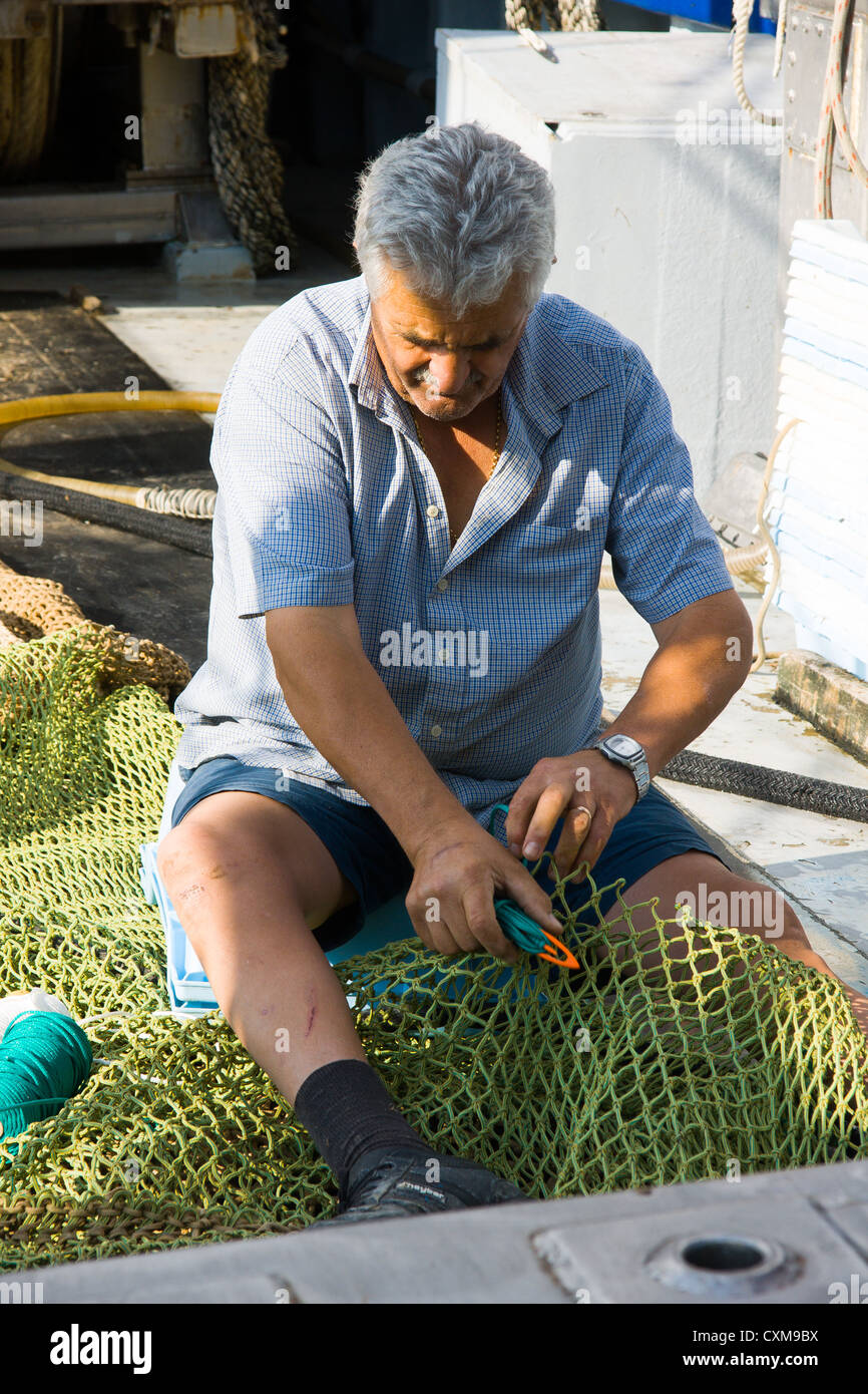 A fisherman mending his nets Stock Photo - Alamy