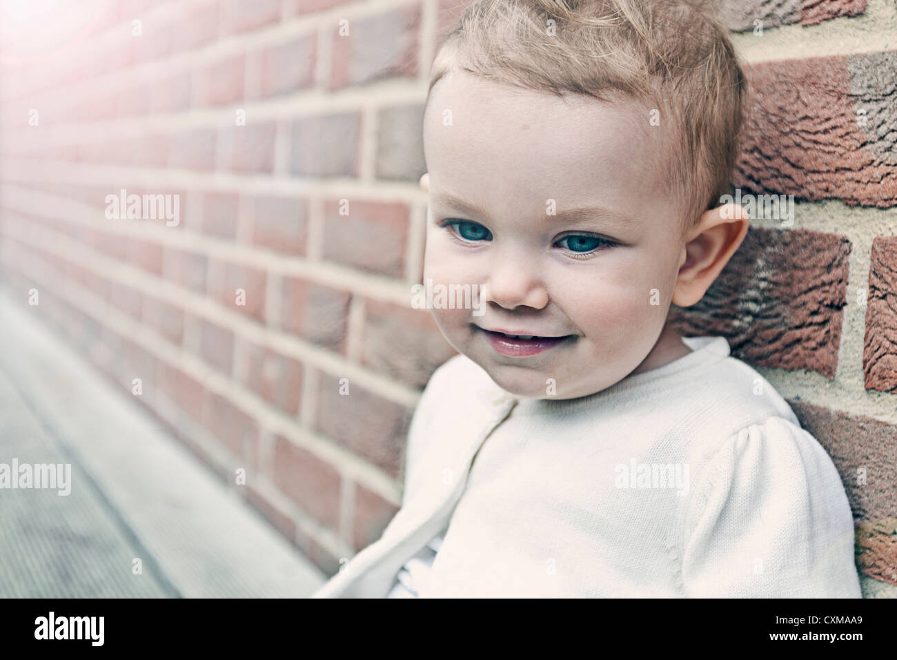 Beautiful Baby Girl against Brick Wall Stock Photo - Alamy