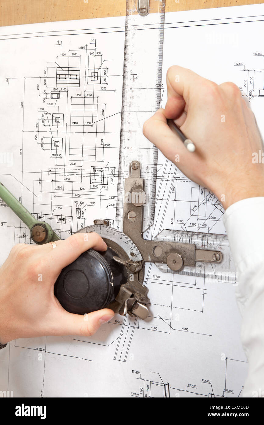 Male hands making a project on blueprint by pencil and rule of drawing ...