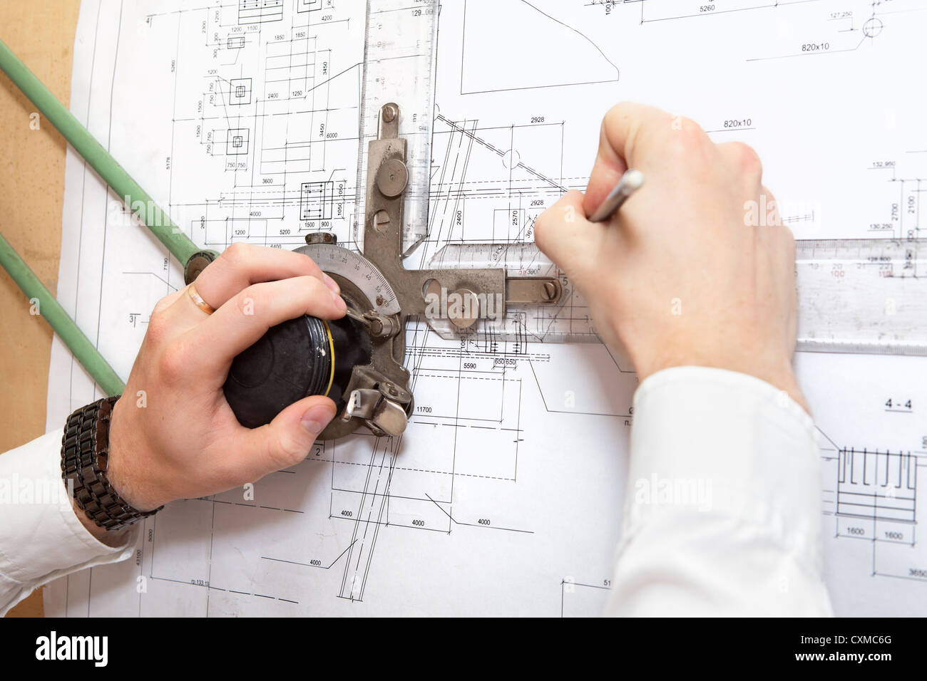 Male hands drawing on blueprint by pencil on white board Stock Photo ...