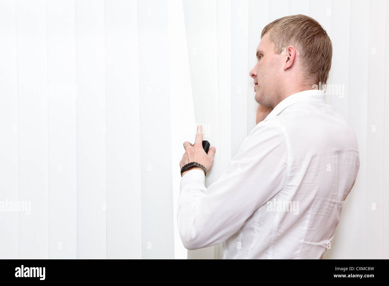 Handsome man standing near window and calling with mobile phone Stock ...