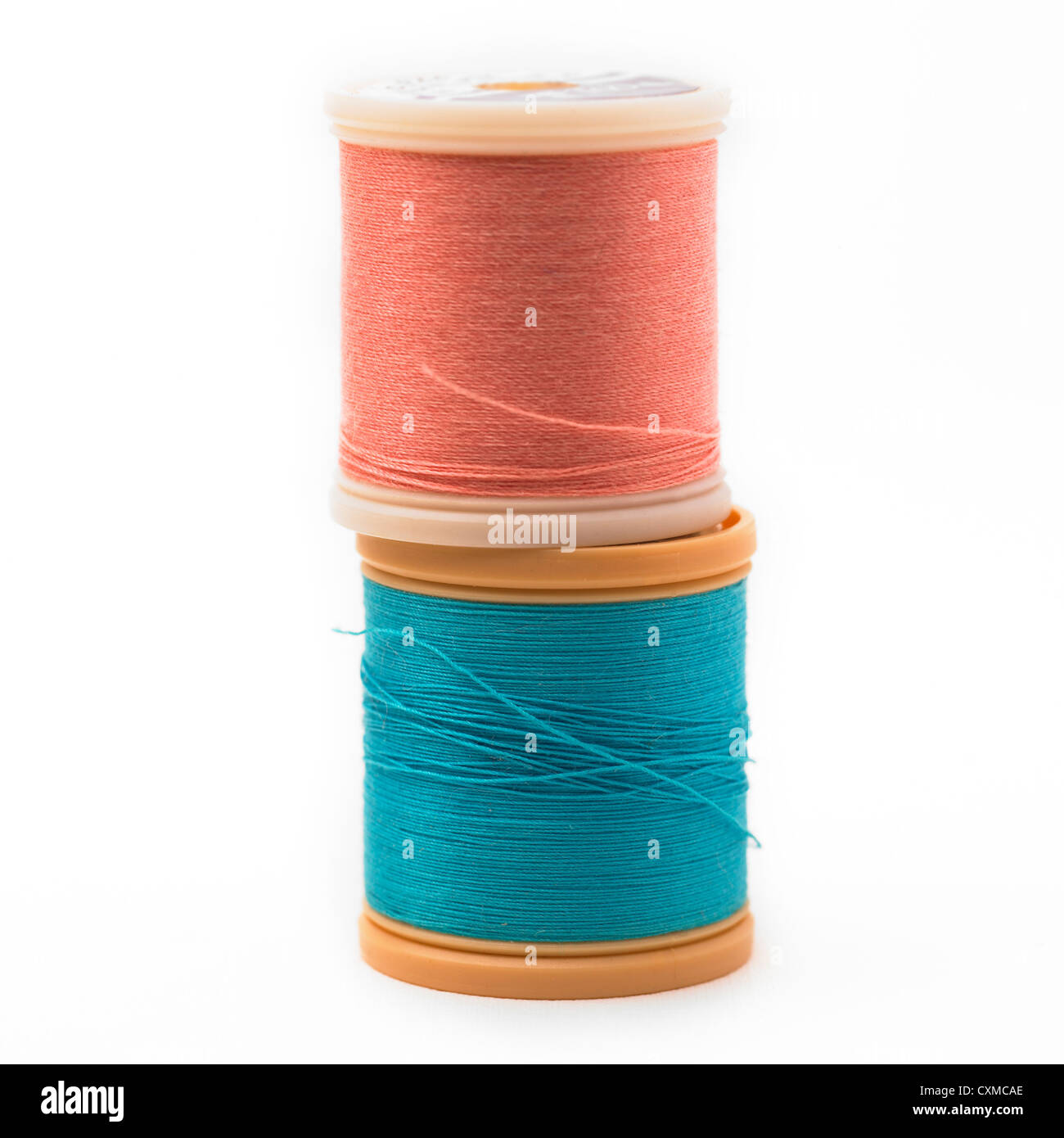 Stacked spools of pink and blue sewing thread on white background Stock ...
