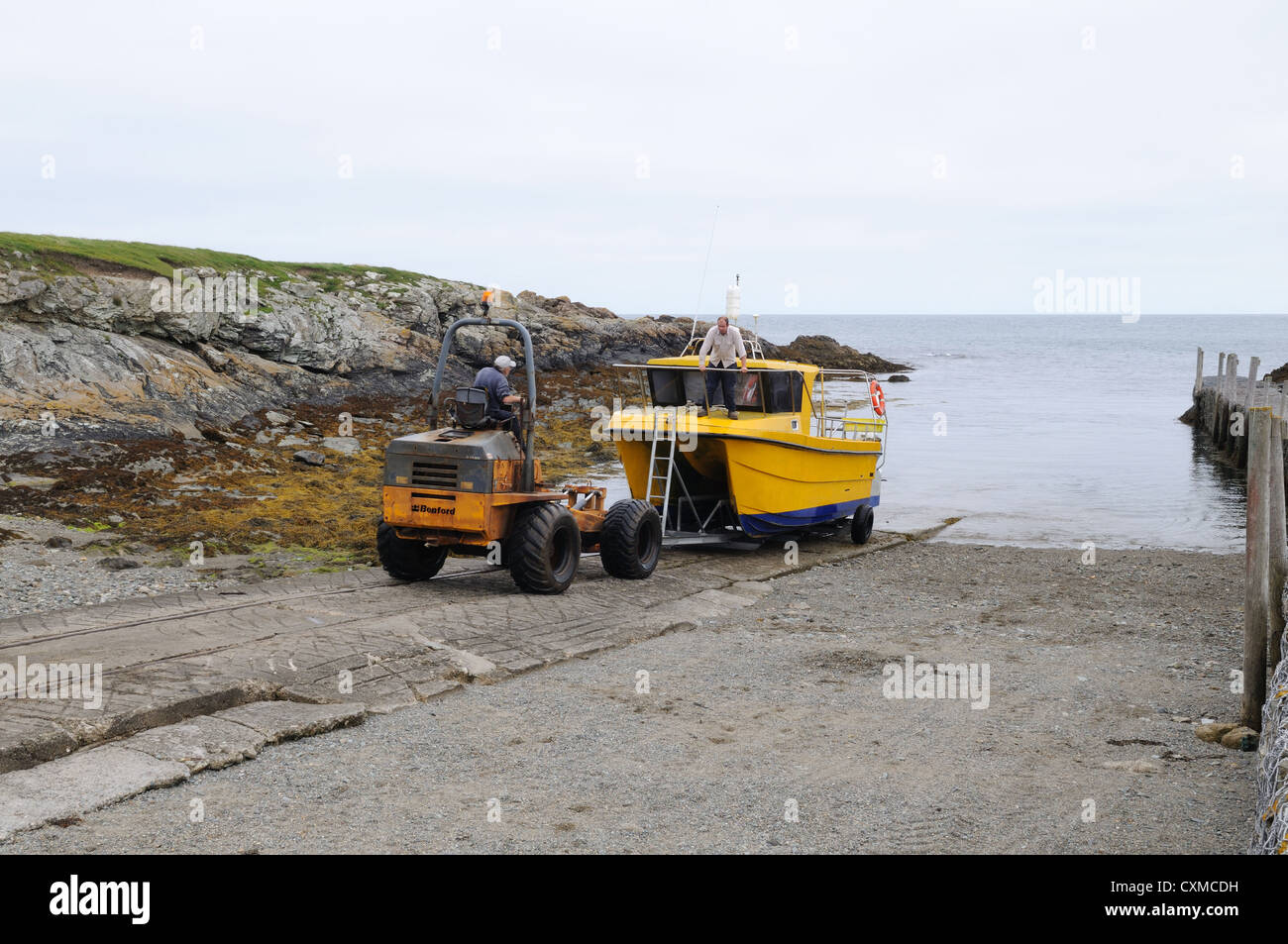 Tractor pulling ferry from the sea for tourists to leave Bardsey Island ...