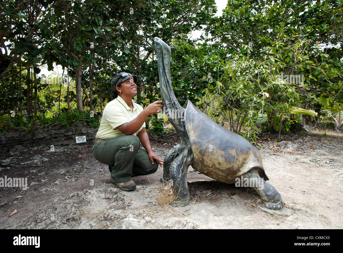 Eco-tour guide squatting beside a bronze statue of an extinct Rodrigues ...