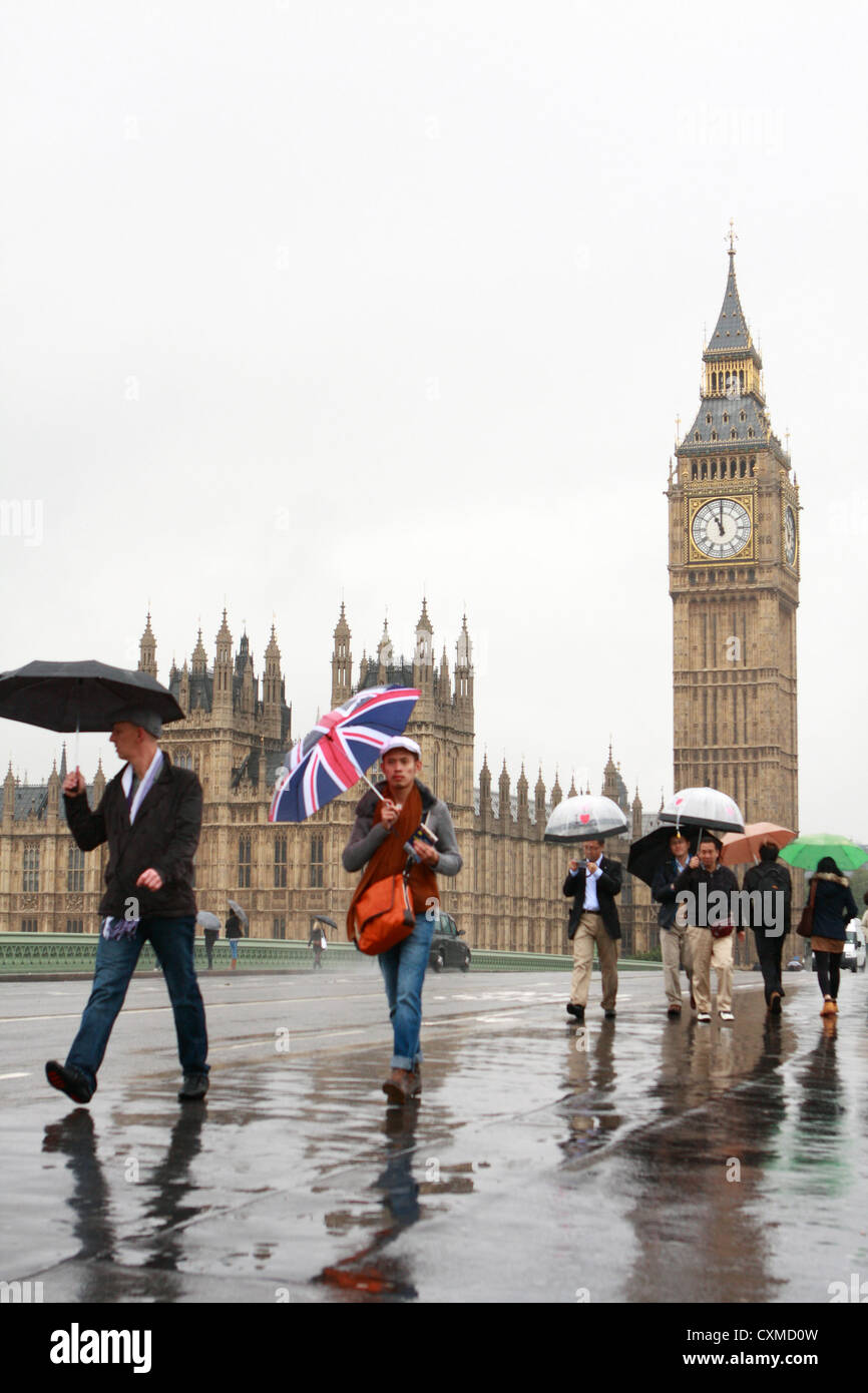 people walking over Westminster Bridge, in the rain, with Big Ben in ...