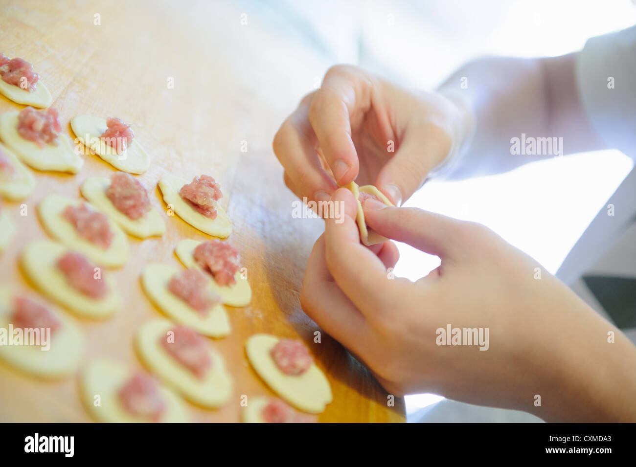 Male cook molding pelmeni on wooden board Stock Photo - Alamy