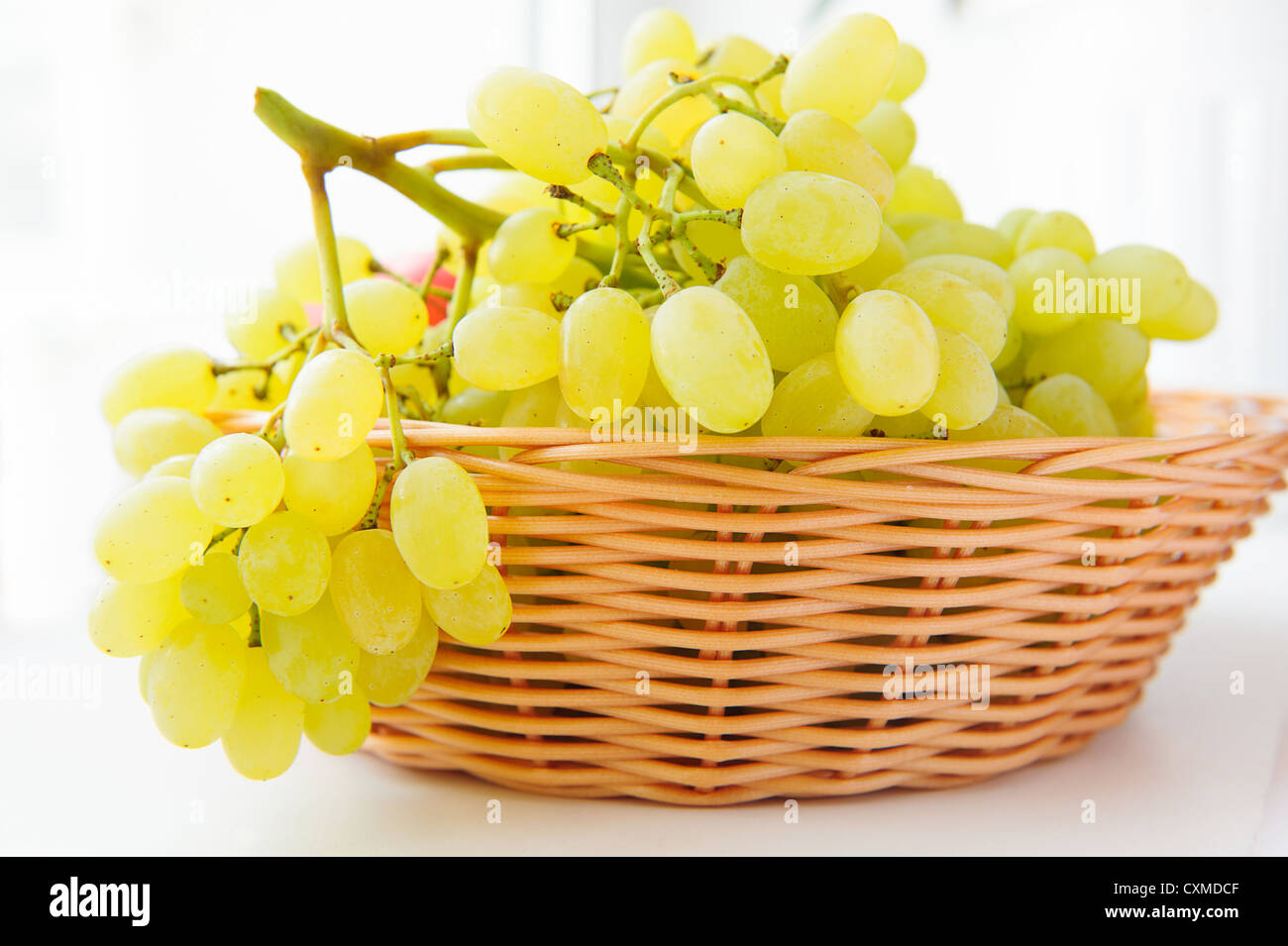 White grapes in basket over light background Stock Photo - Alamy
