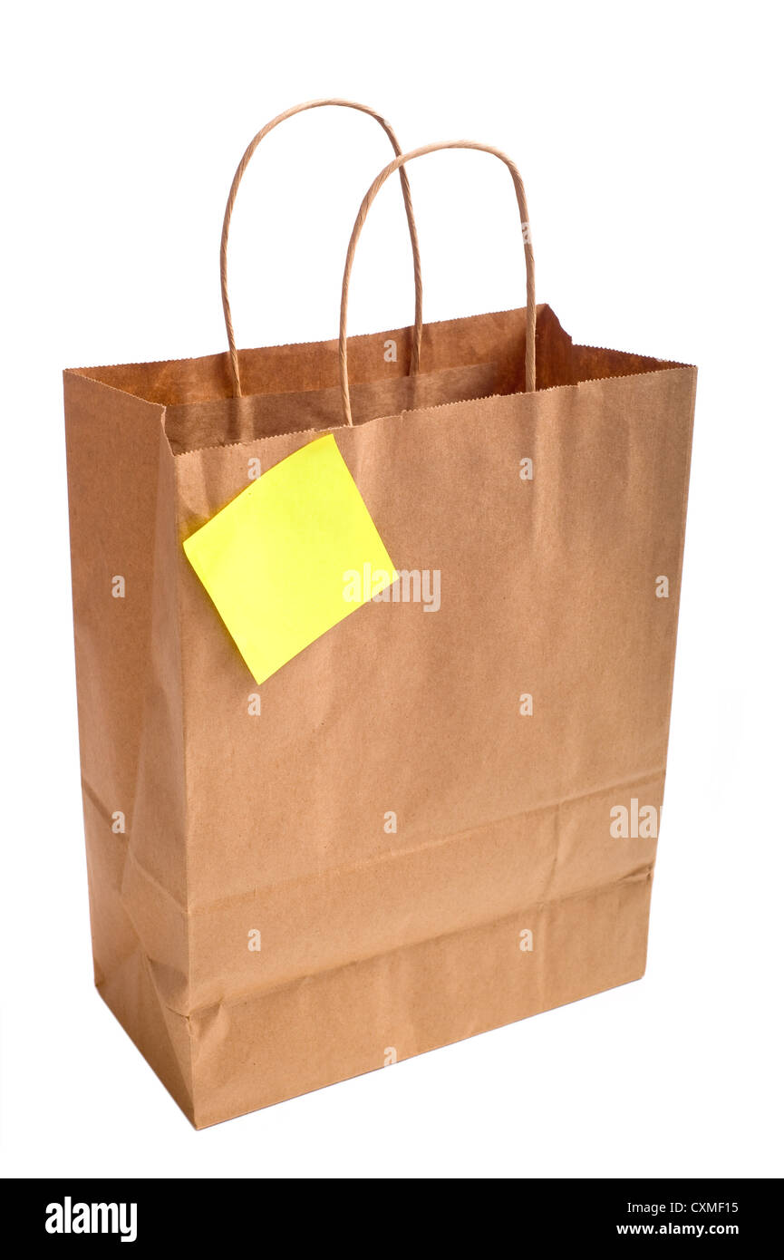 A brown shopping bag with handles with a post-it note or sticky note ...