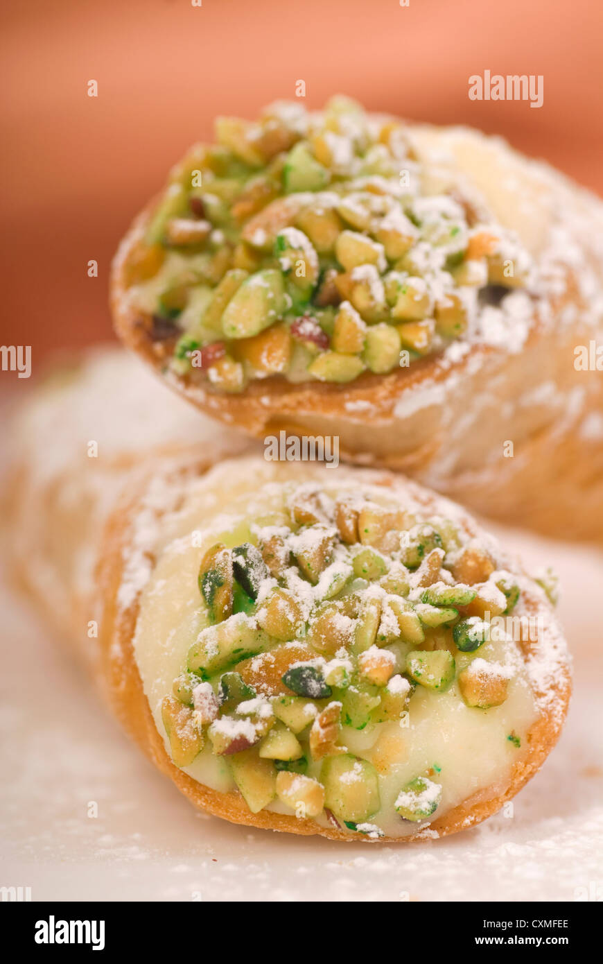 Two freshly baked cannoli stacked on each other and dusted with ...
