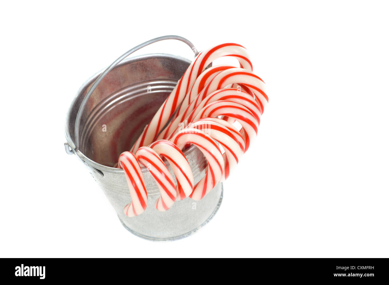 A silver bucket of Christmas time Candy Canes on a white background ...