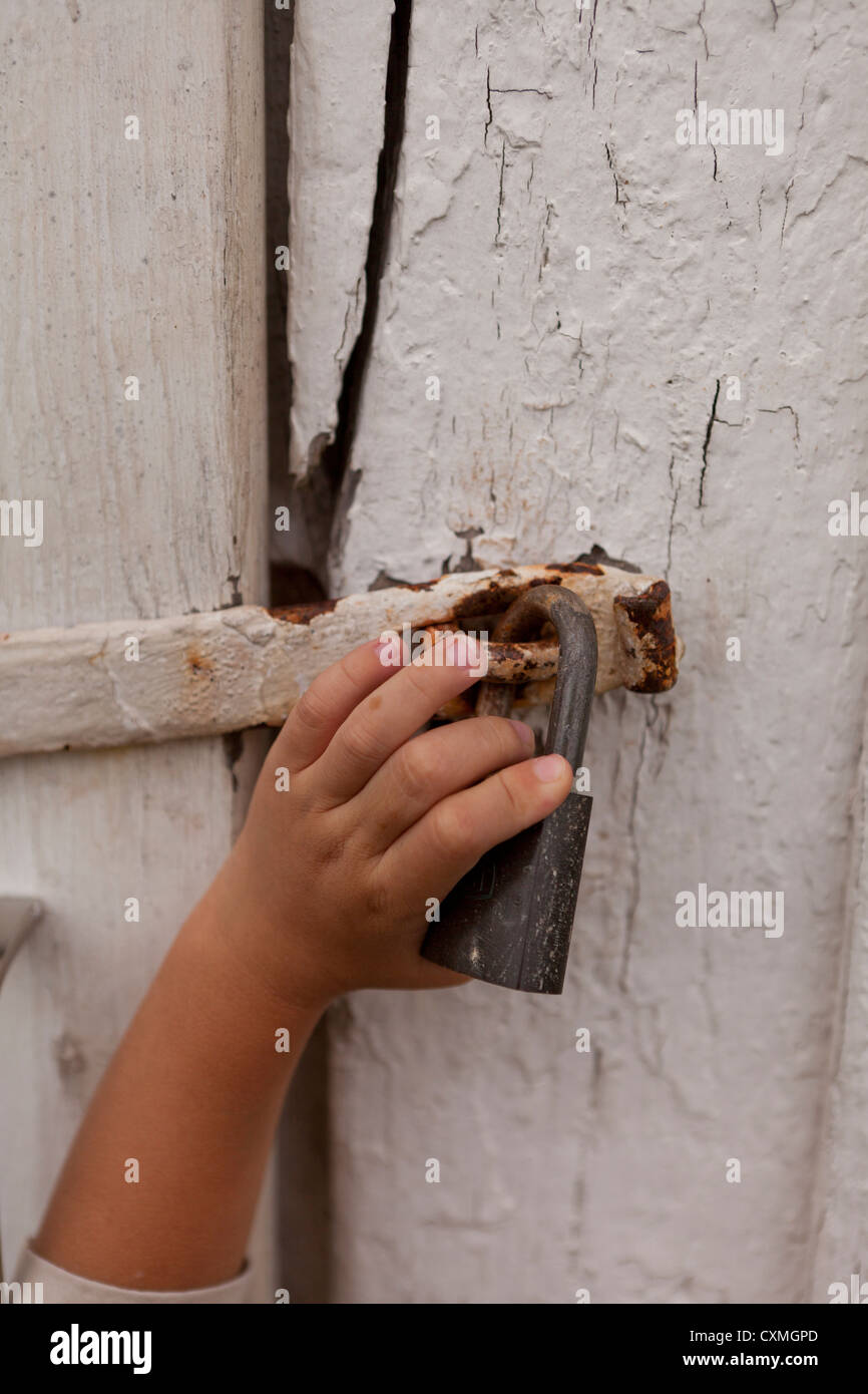 Young boy's hand on padlock Stock Photo - Alamy