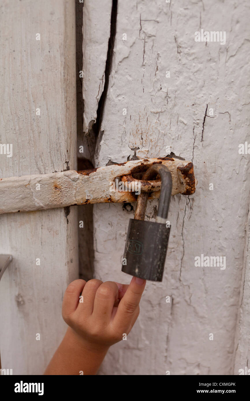 Young boy's hand on padlock Stock Photo - Alamy