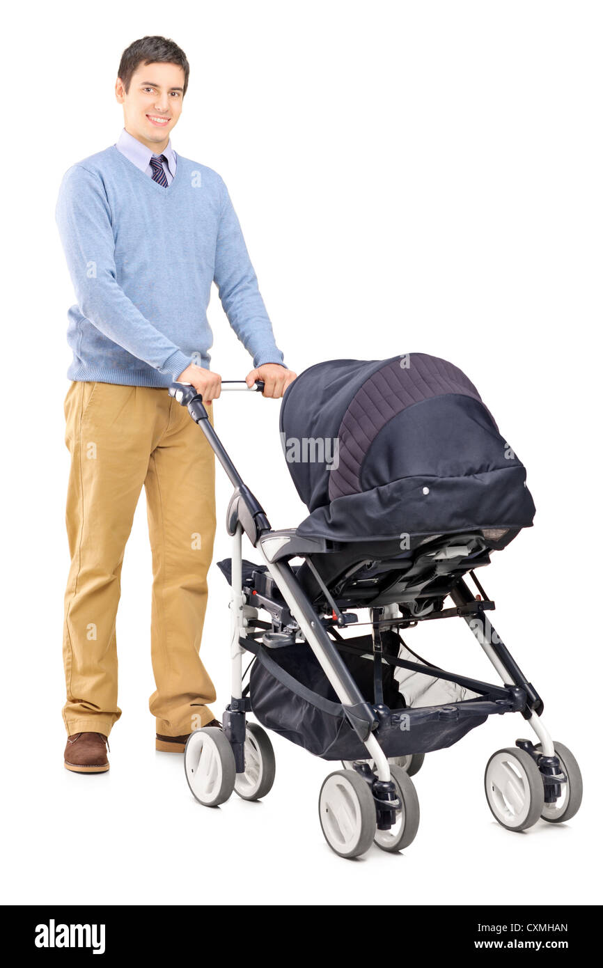 Full length portrait of a young male pushing a baby stroller isolated ...