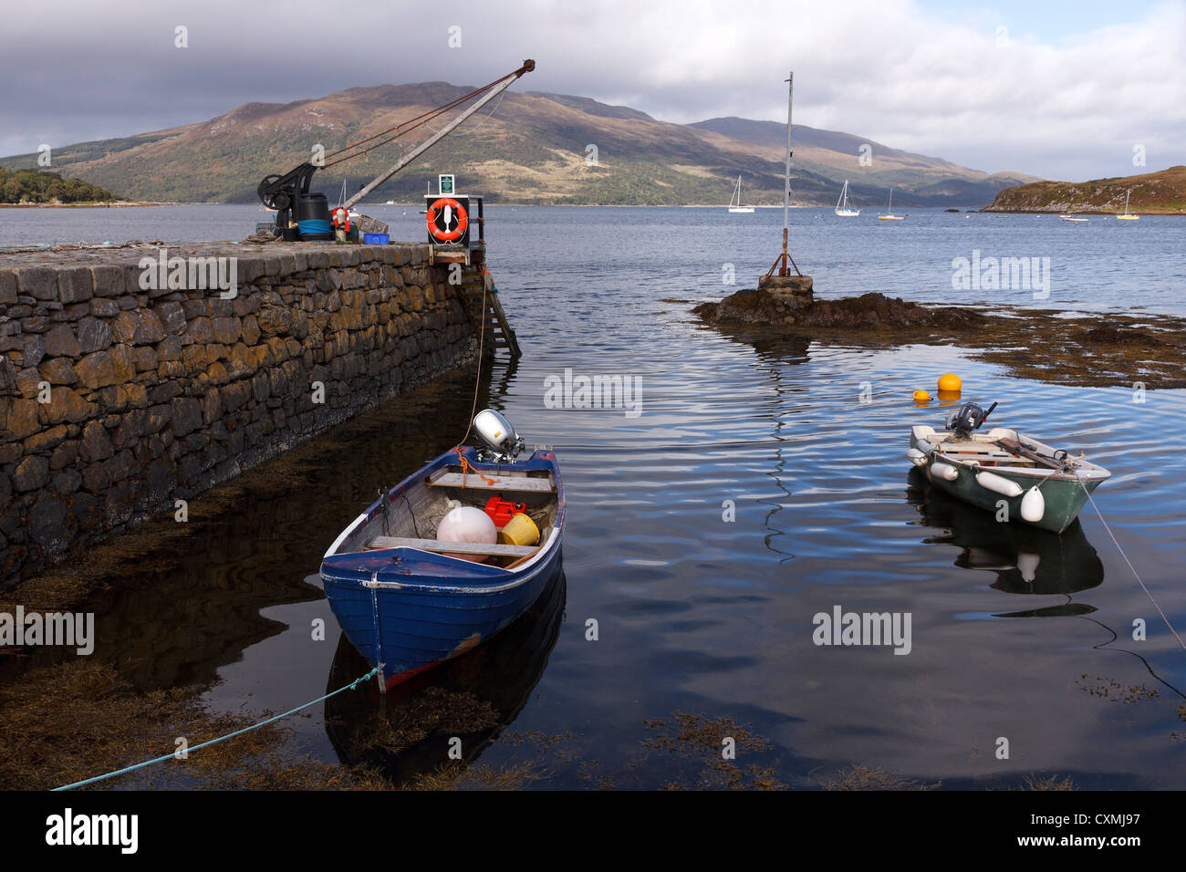 Small boats moored in a tiny harbour with little loading crane at Isle ...