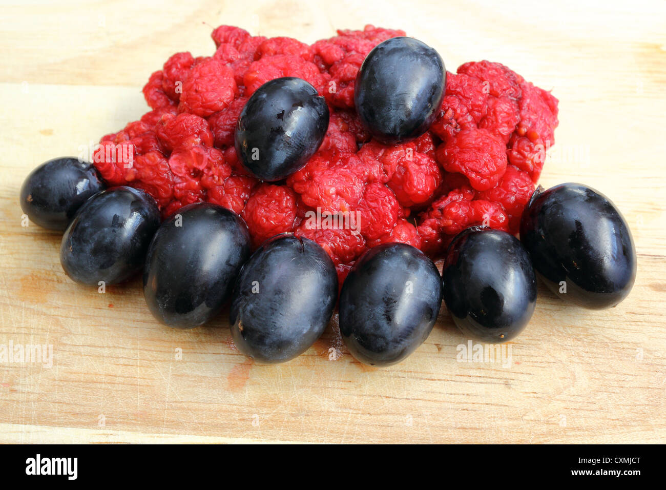 wild raspberry from the freezer and red grapes Stock Photo - Alamy