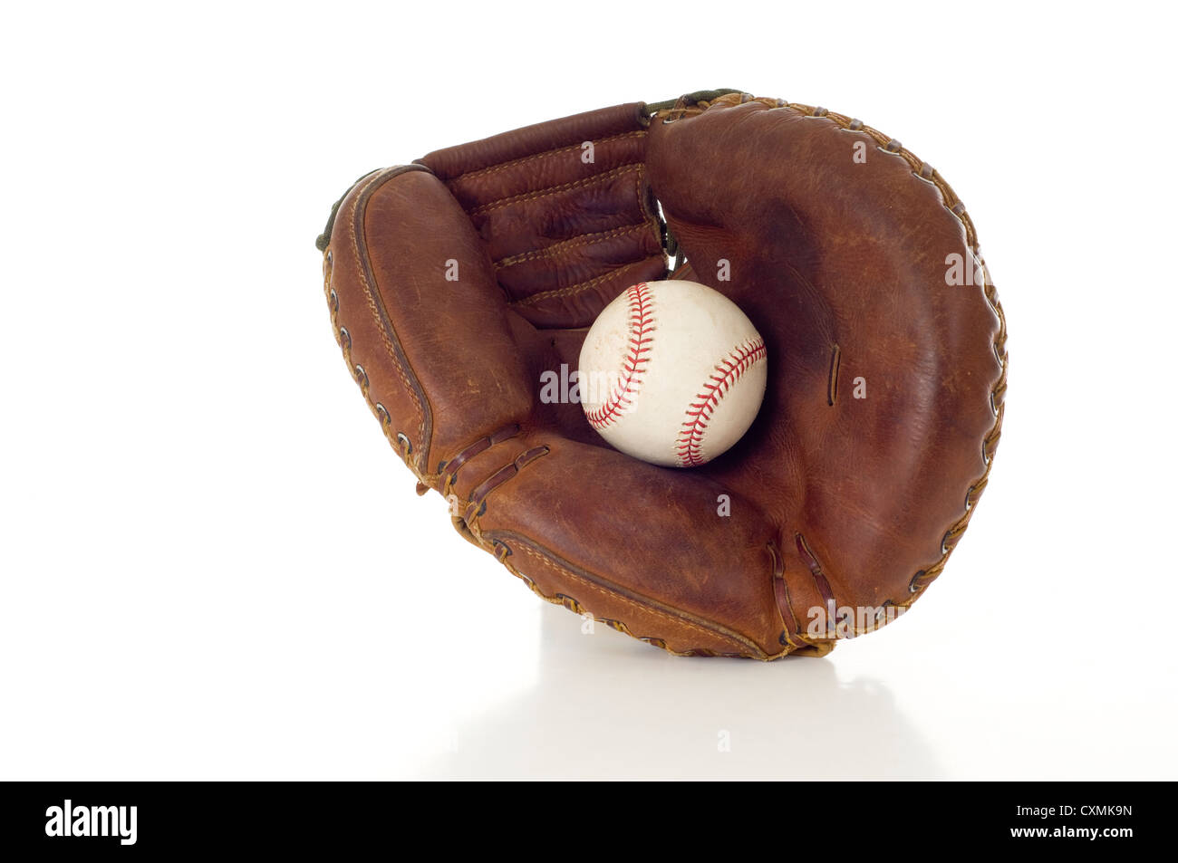 A brown leather baseball mitt with a white leather baseball on a white ...