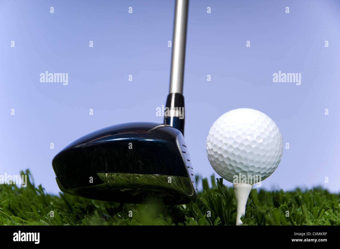 A golf club (driver) about to strike a golf ball on a tee Stock Photo ...