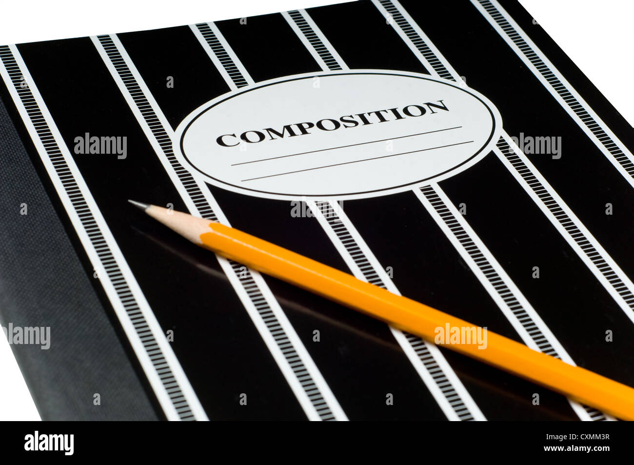 A black and white striped composition book and a yellow pencil on a ...