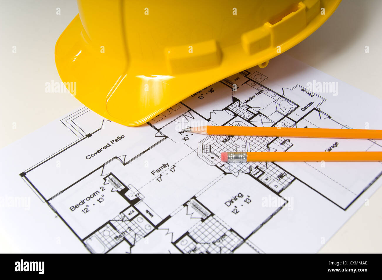 House floor plan design with pencils and a yellow hard hat Stock Photo ...