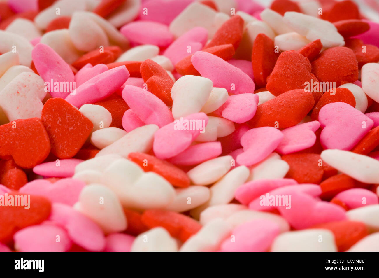 Extreme close-up of tiny candy hearts in red, pink and white for ...