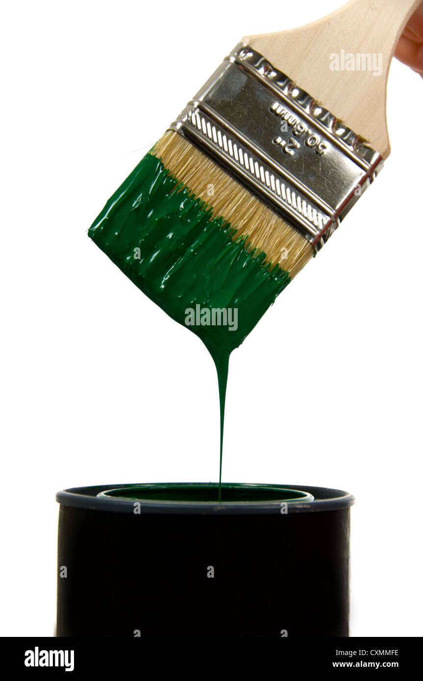 Green paint dripping off of brush into can Stock Photo - Alamy